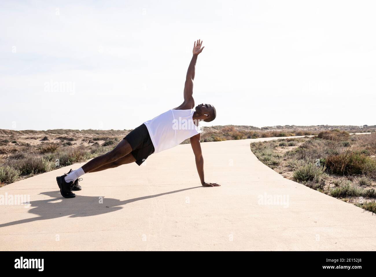 Young black runner in profile doing push-ups and lifting one arm Stock ...