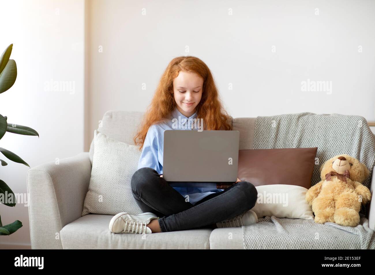 Ginger hair girl using laptop for elearning, sitting on couch Stock ...