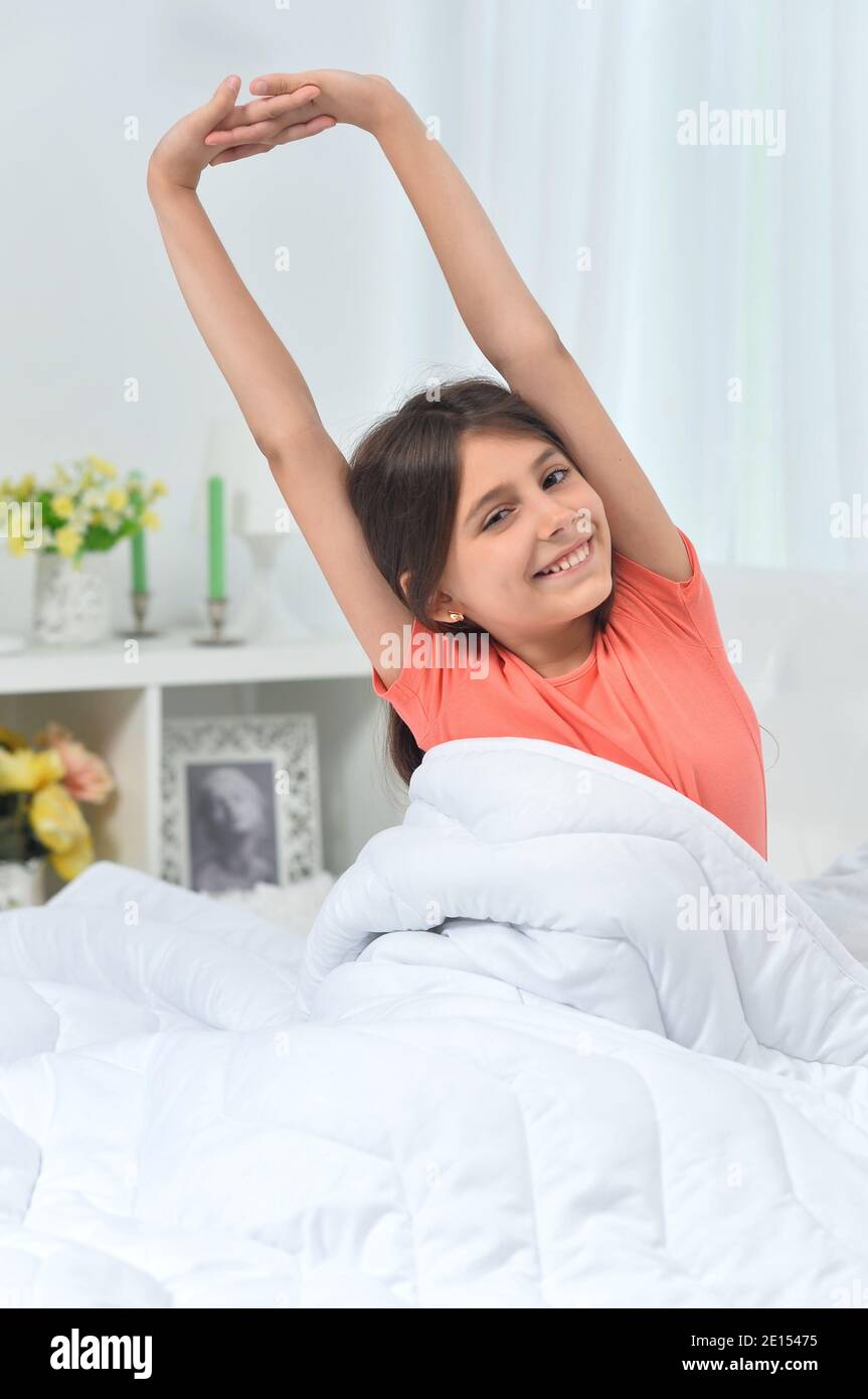Cute little girl waking up in bed Stock Photo - Alamy