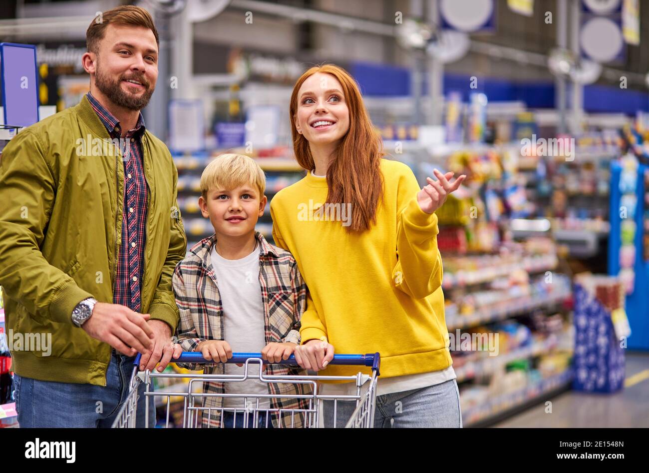 family with child boy shopping together in grocery store, man woman and ...