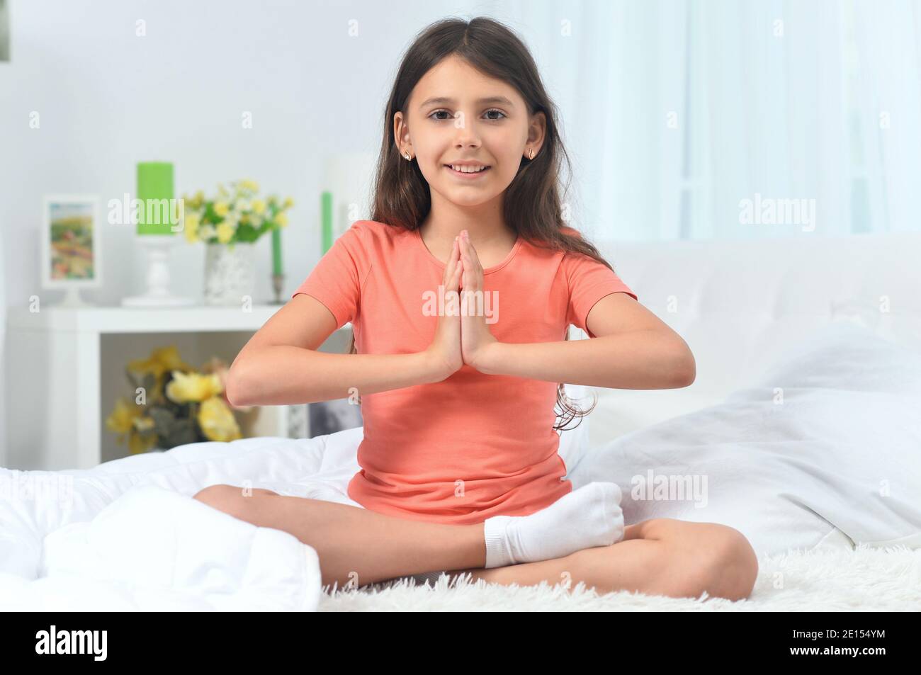 Cute little girl doing yoga in bed Stock Photo - Alamy