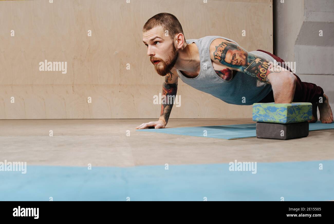 Resolved young disabled armless man training, doing push ups with help ...