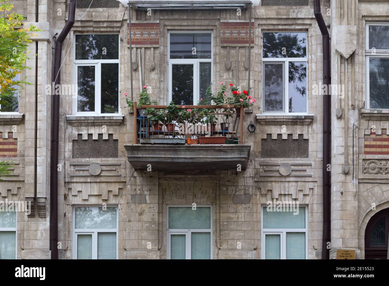 The facade of an old house with flowers on the balcony. House on August ...