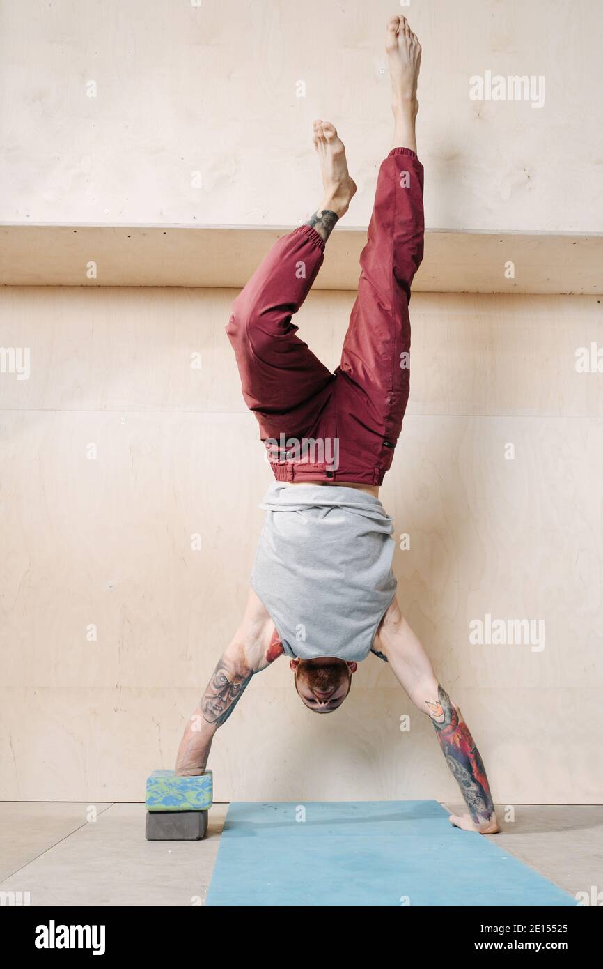 Young disabled armless man doing handstand with wall assist Stock Photo ...