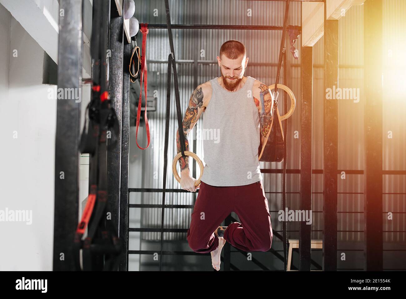 Strong young disabled armless man training in the gym hanging on ...
