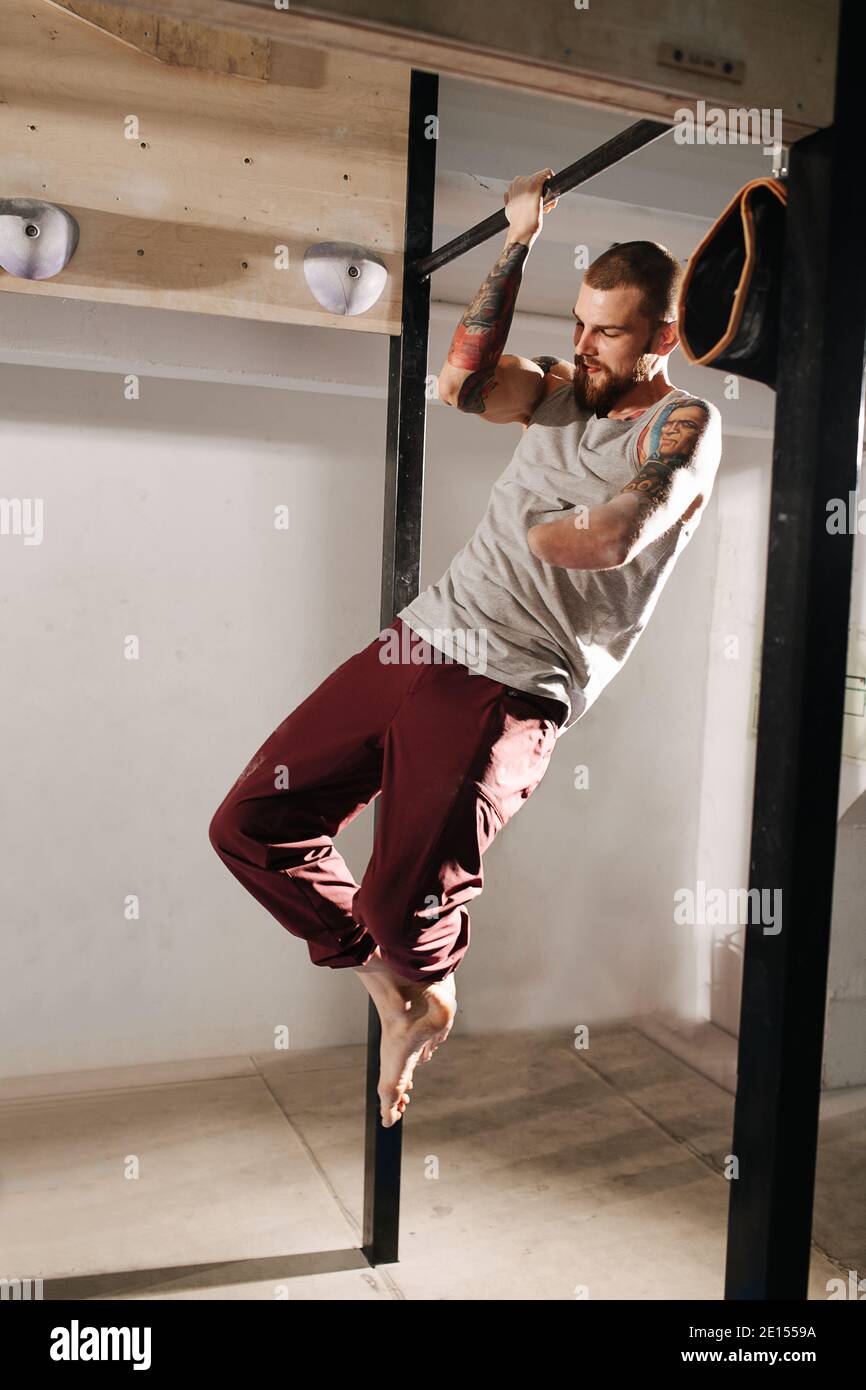 Working out armless man training in the gym, doing pull ups with one ...