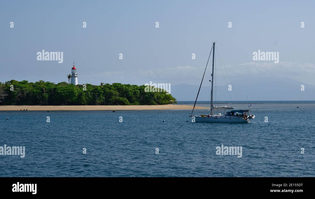 Boat in the ocean with lighthouse in the background, Port Douglas ...