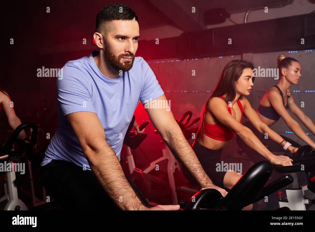 people working out on the exercise bike at the gym, intense cardio ...