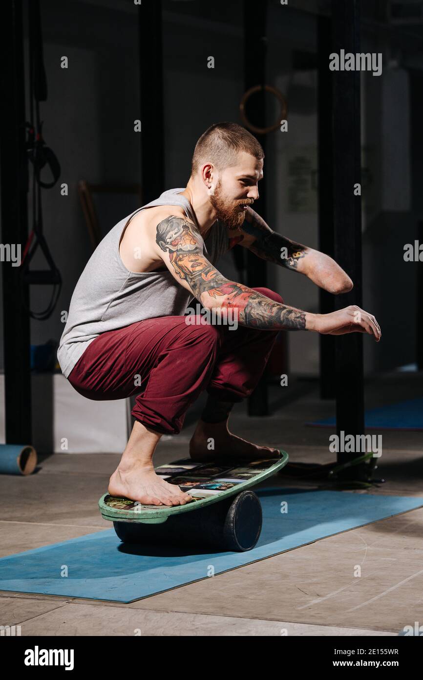 Coordinated young disabled armless man balancing on a roller board ...