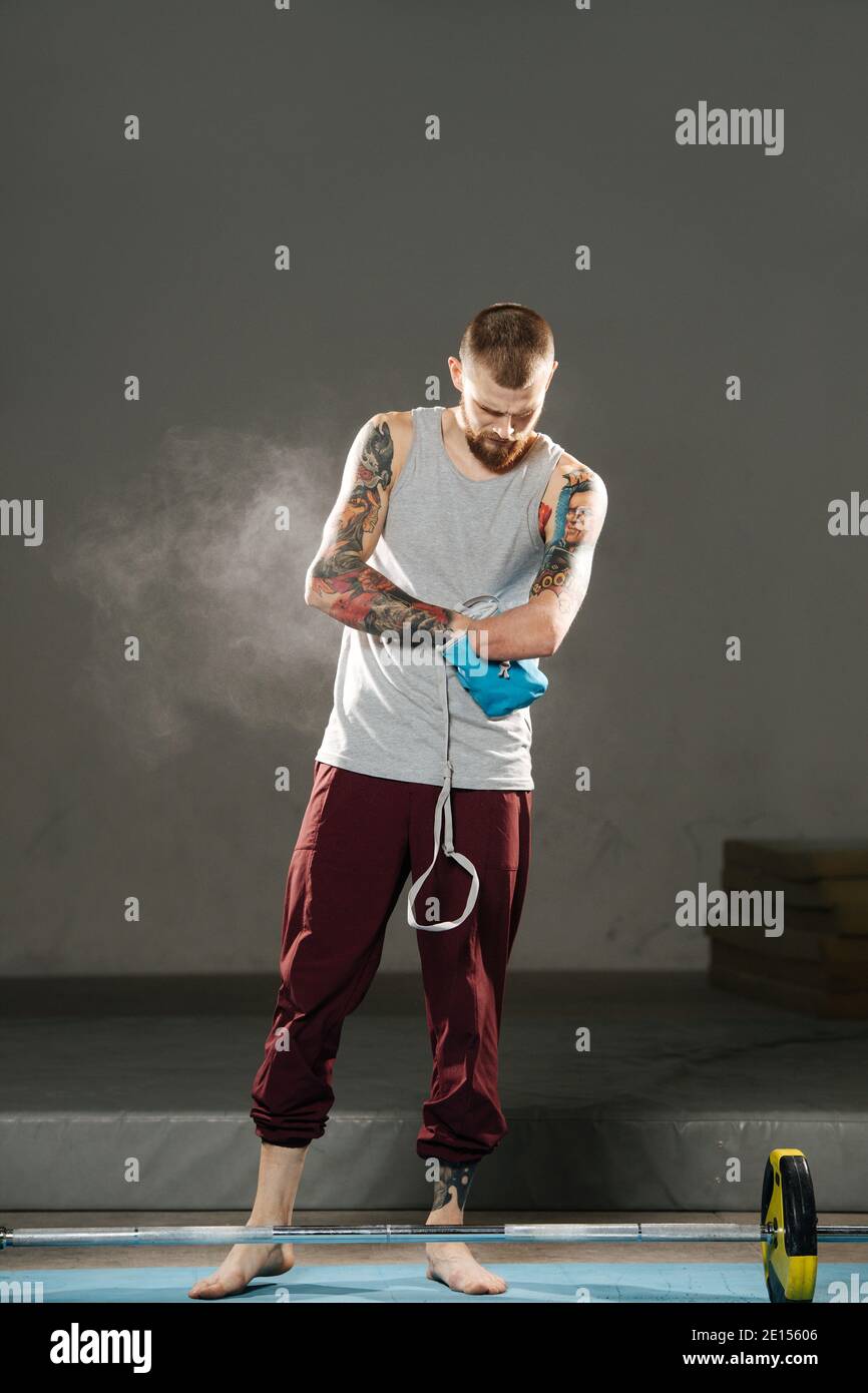Focused young disabled armless man training in the gym, applying talcum ...