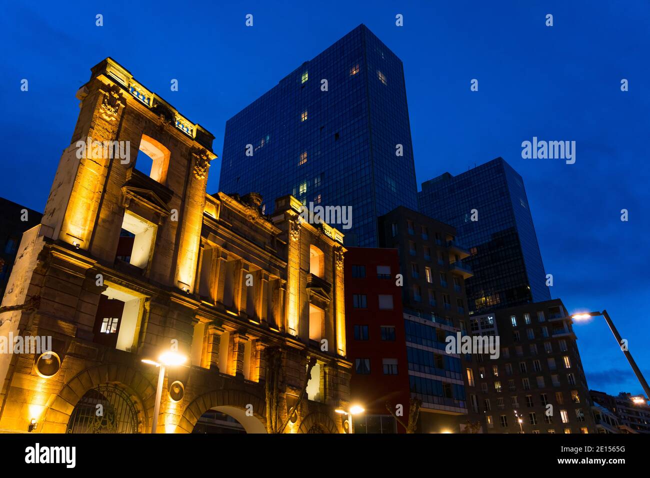 Facade of an old building and in the background the Torres de Isozaki ...