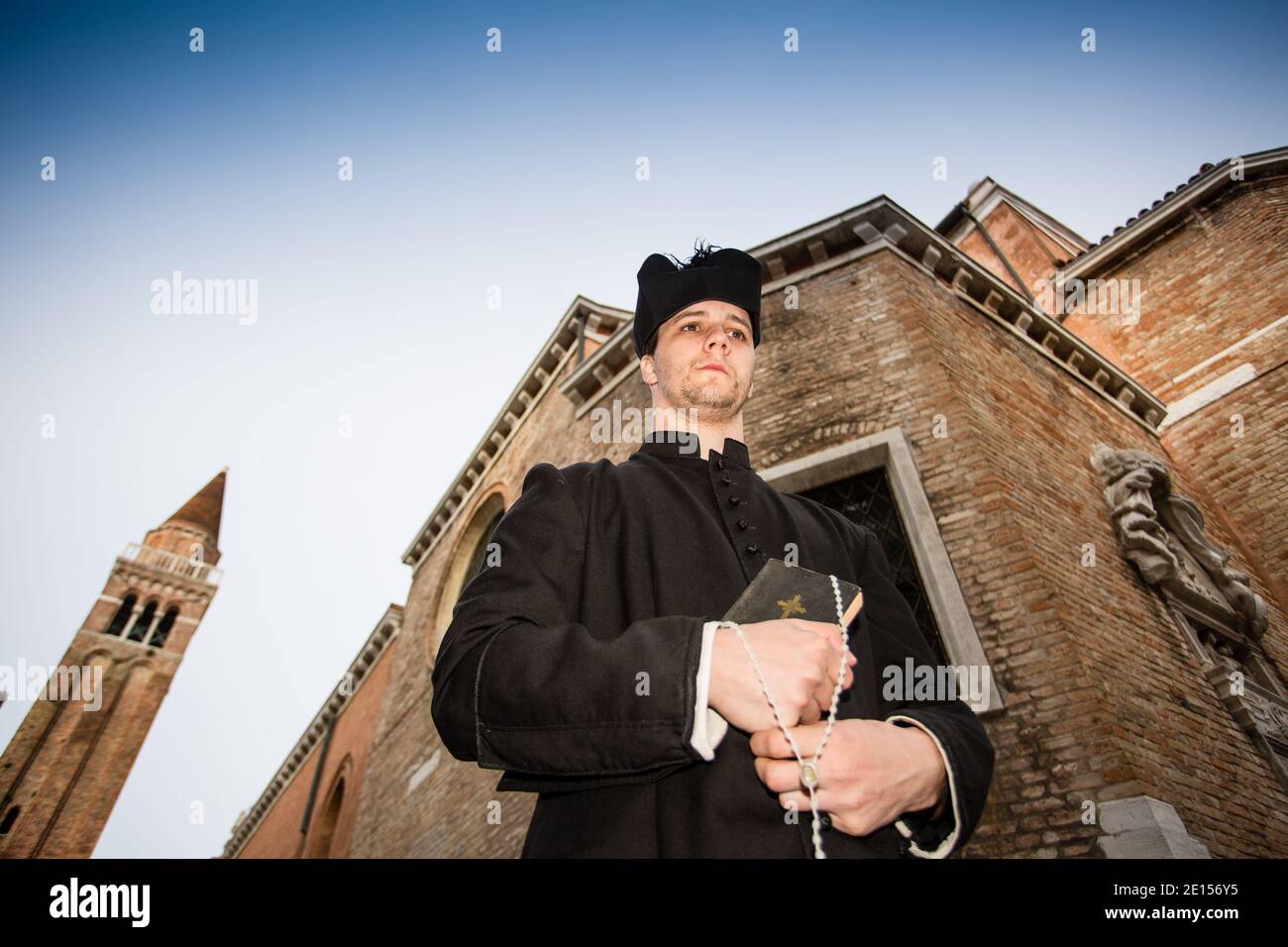 young priest in venice with church Stock Photo - Alamy