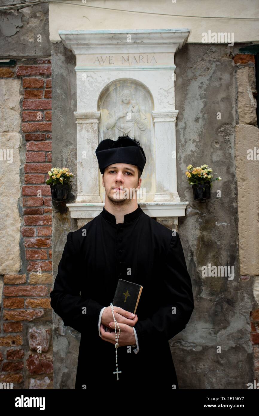Young priest holding crucifix hi-res stock photography and images - Alamy