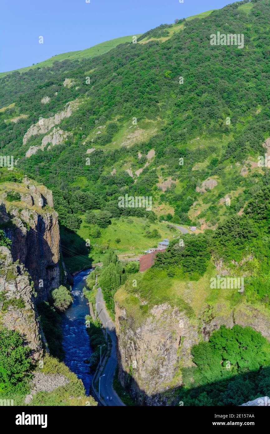 River flows through a steep green mountain gorge with cliffs and dense ...
