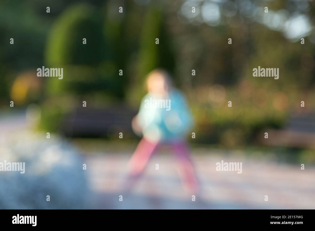 Little kid have fun jumping in the park. It is a bright positive ...
