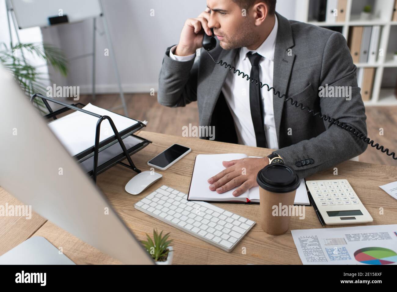 serious businessman talking on telephone at workplace in office Stock ...