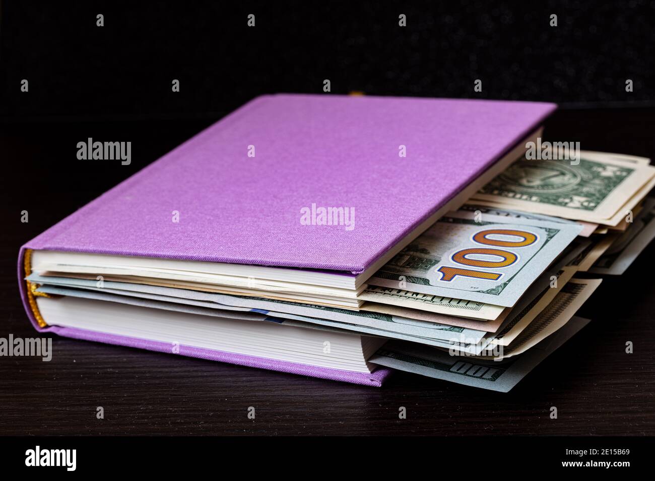 dollar banknotes in violet book Stock Photo - Alamy