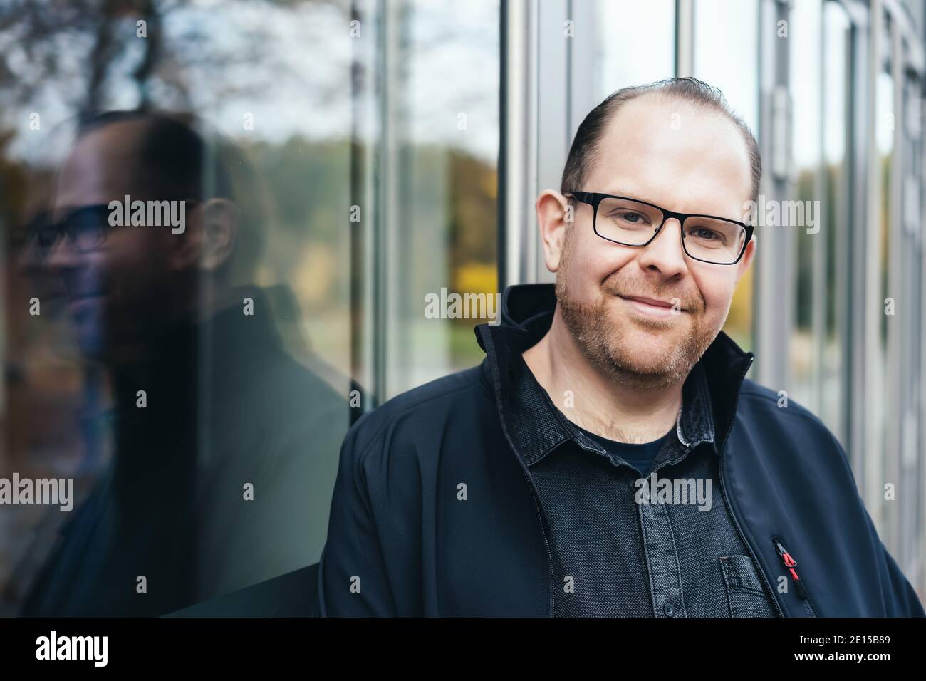 portrait picture of a young man leaning against windows Stock Photo - Alamy