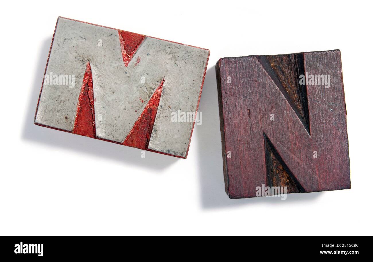 Letterpress tall M and N print blocks photographed on a white ...
