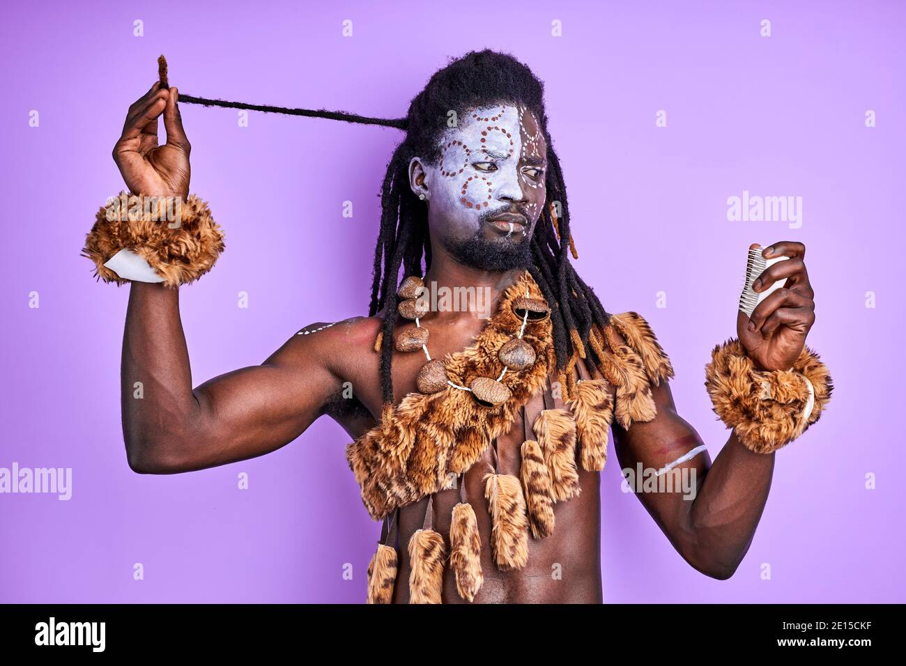 tribal male trying to understand how to use modern combs for hair, hold ...