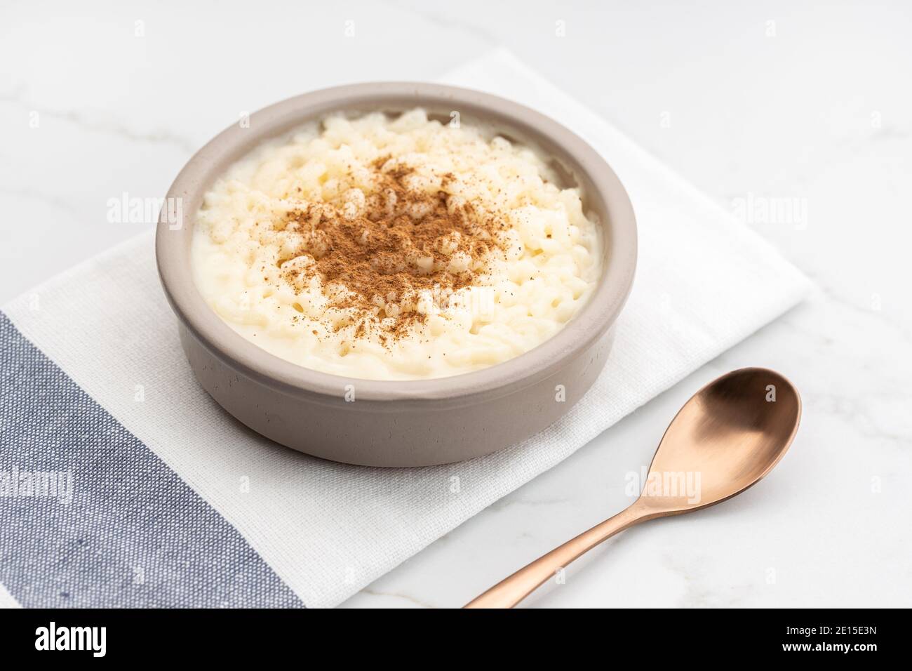 Creamy rice pudding with cinnamon in bowl on white marble table ...