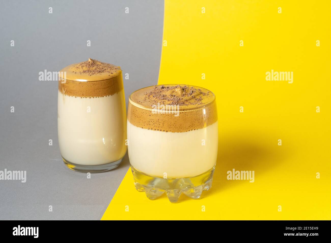 Two glasses of dalgon coffee with lush froth on a gray-yellow ...
