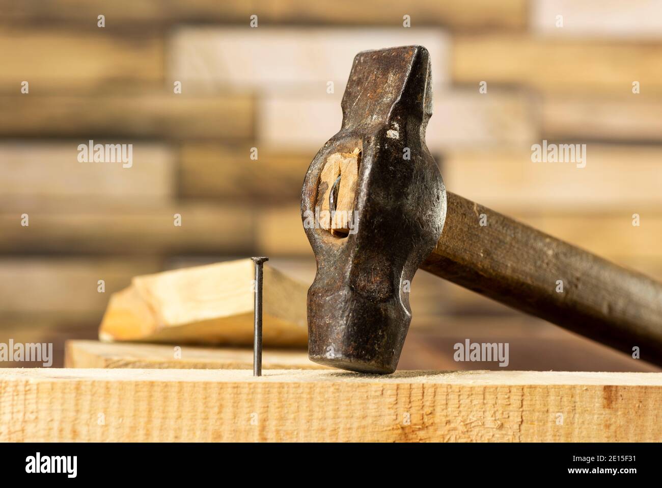 Hammer a nail into a wooden board, work, carpentry, close up hammering ...