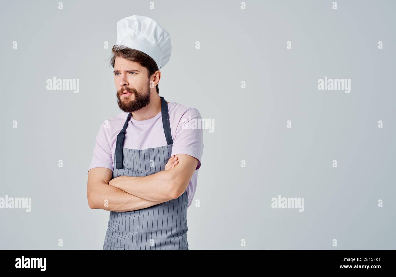 A man in a gray aprons and a headdress is gesturing with his hands as a ...