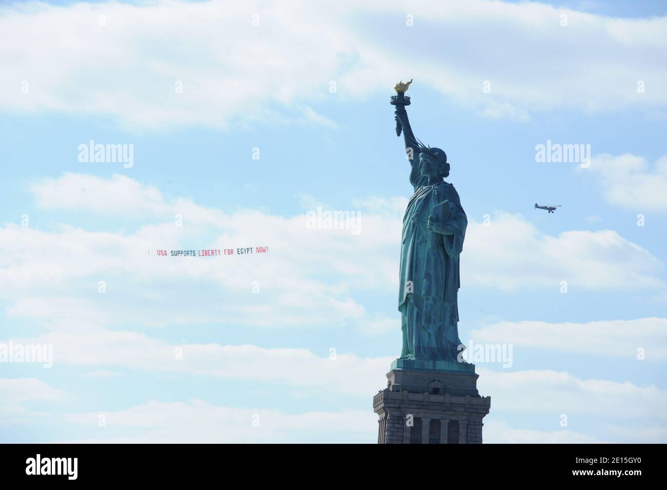 A plane flying over manhattan with a flag saying 'USA supports Liberty ...