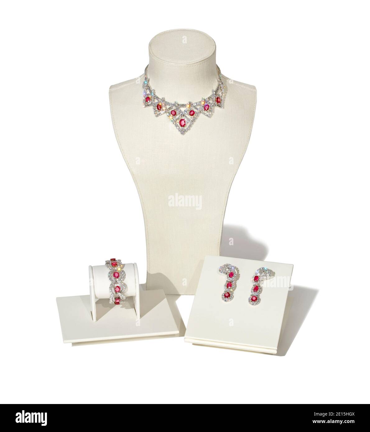 Set of ruby and diamond jewelry on display photographed on a white ...