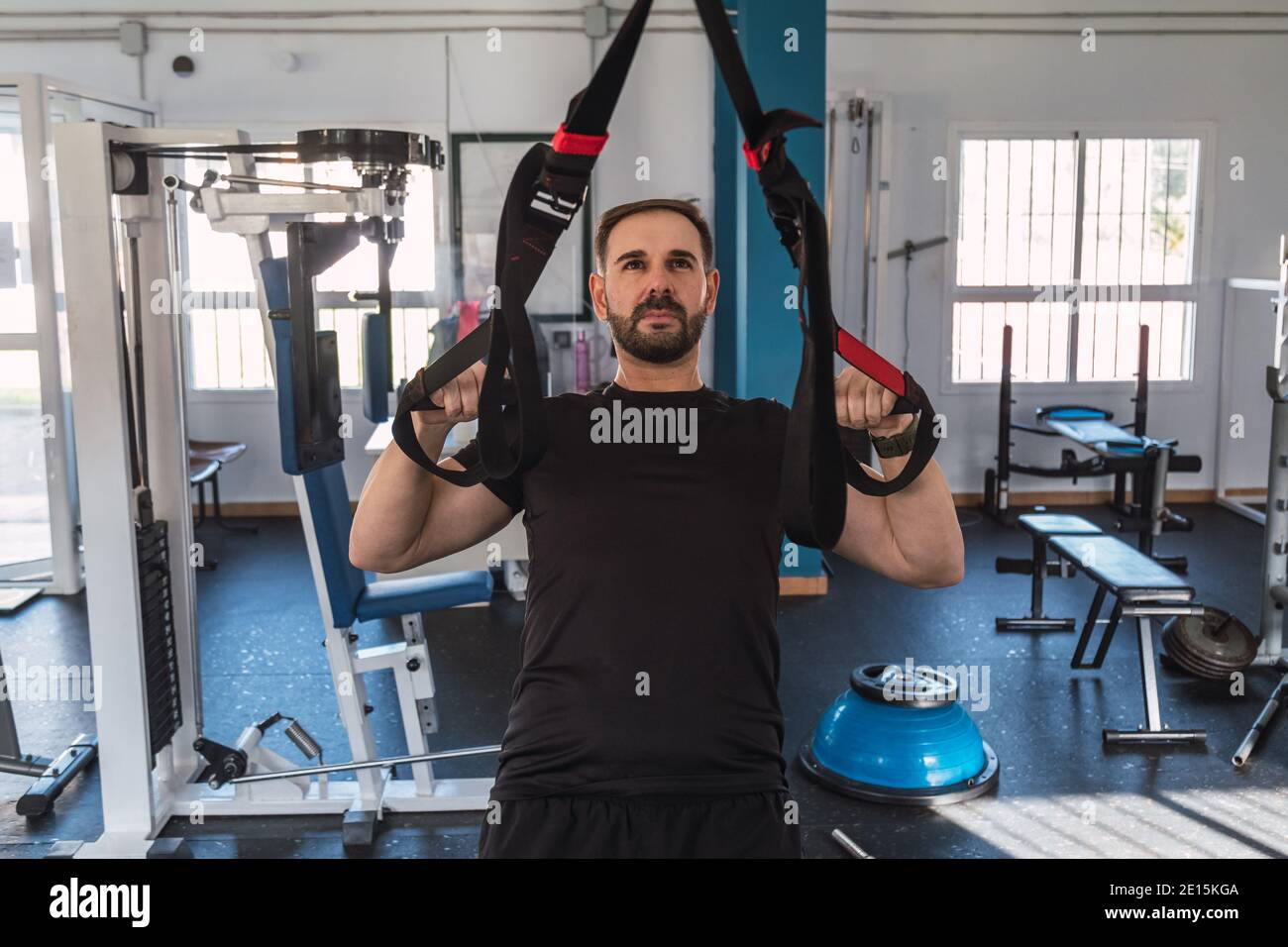 Young man doing TRX exercises at the gym. TRX training Stock Photo - Alamy