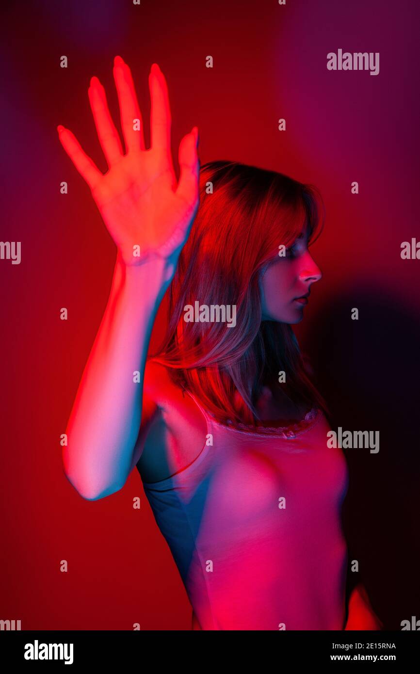 Anonymous woman covering face with hand in red neon light Stock Photo ...