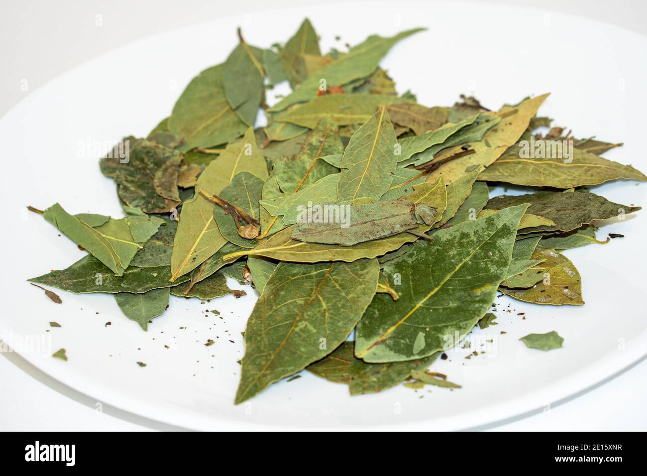 Dried green bay leaves on a white spice plate Stock Photo - Alamy