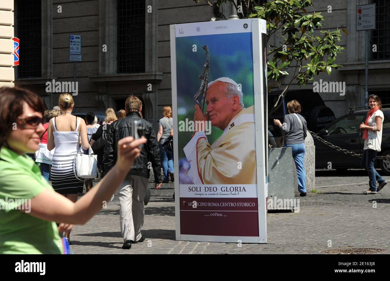 People walk past placards showing pictures of late pope John Paul II ...