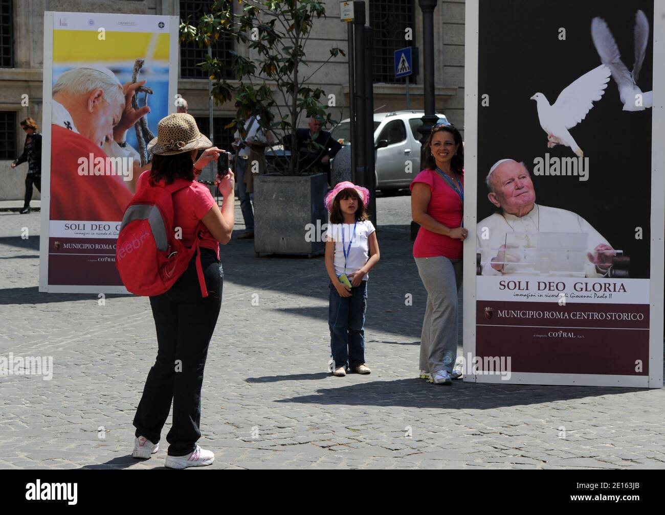 People walk past placards showing pictures of late pope John Paul II ...