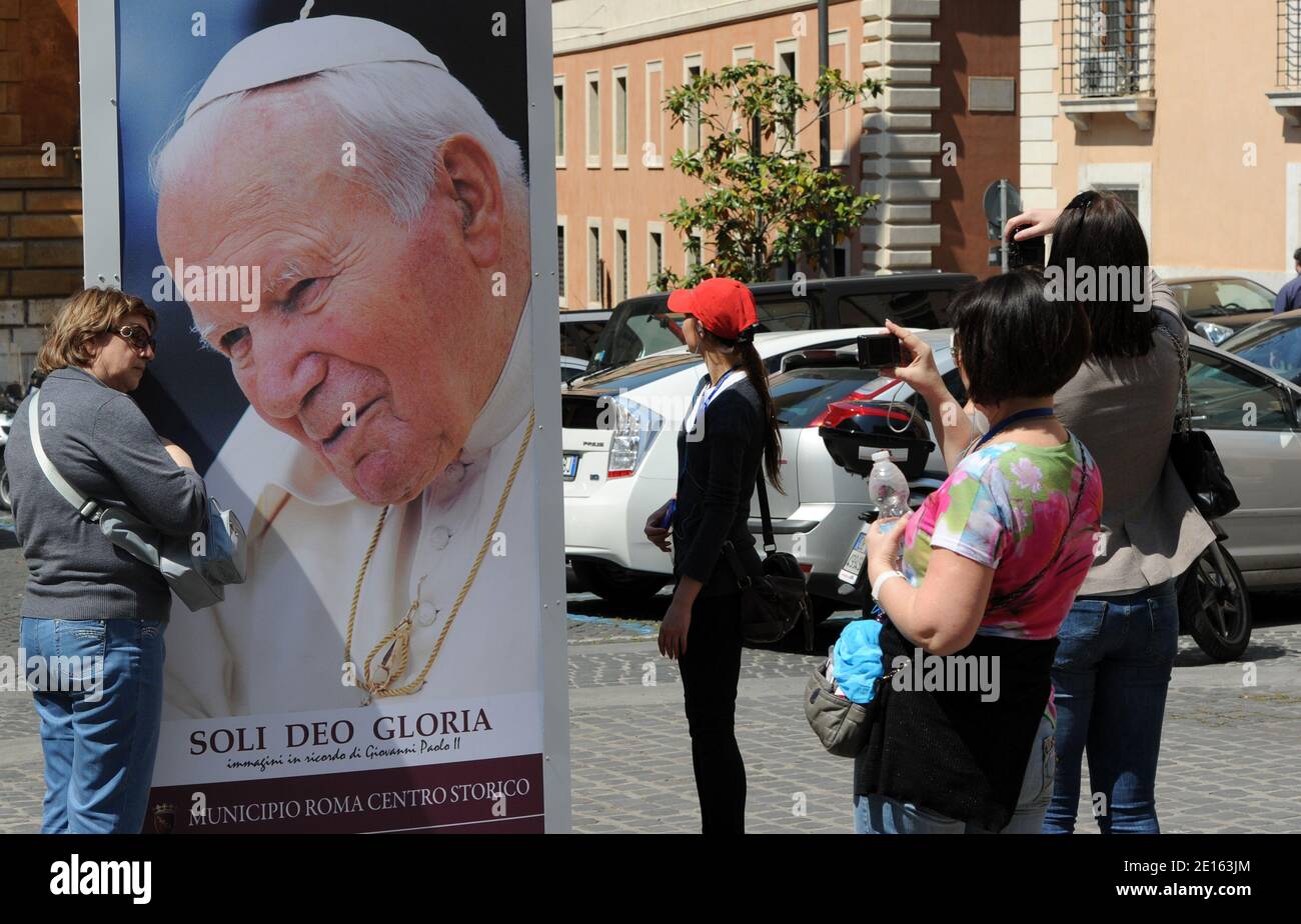 People walk past placards showing pictures of late pope John Paul II ...