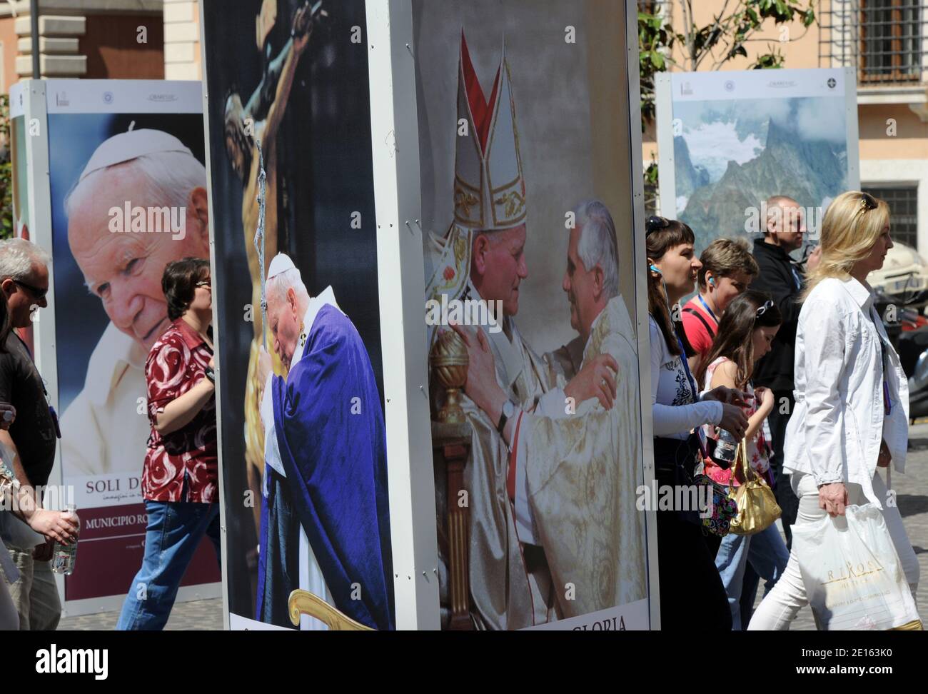 People walk past placards showing pictures of late pope John Paul II ...