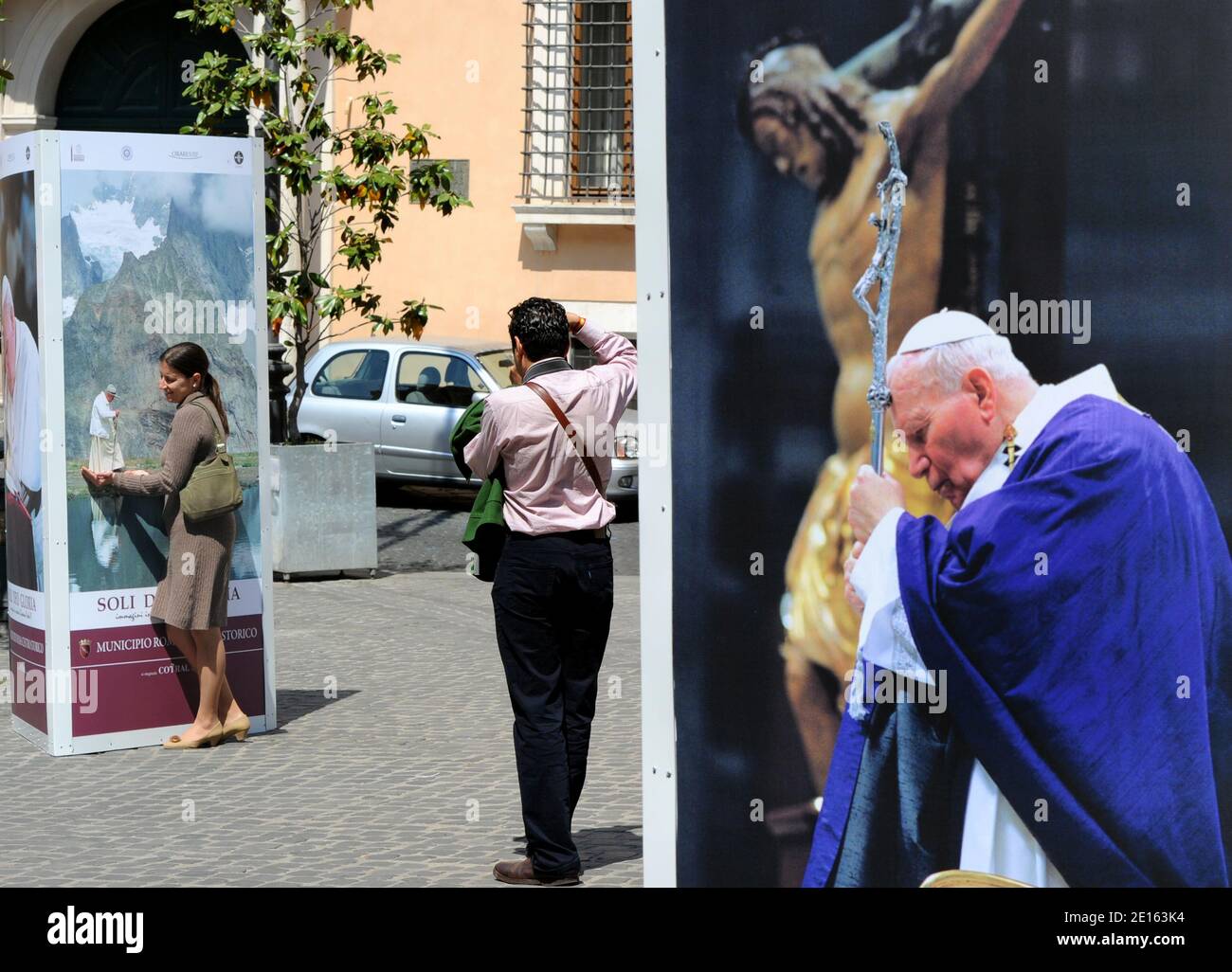 People walk past placards showing pictures of late pope John Paul II ...