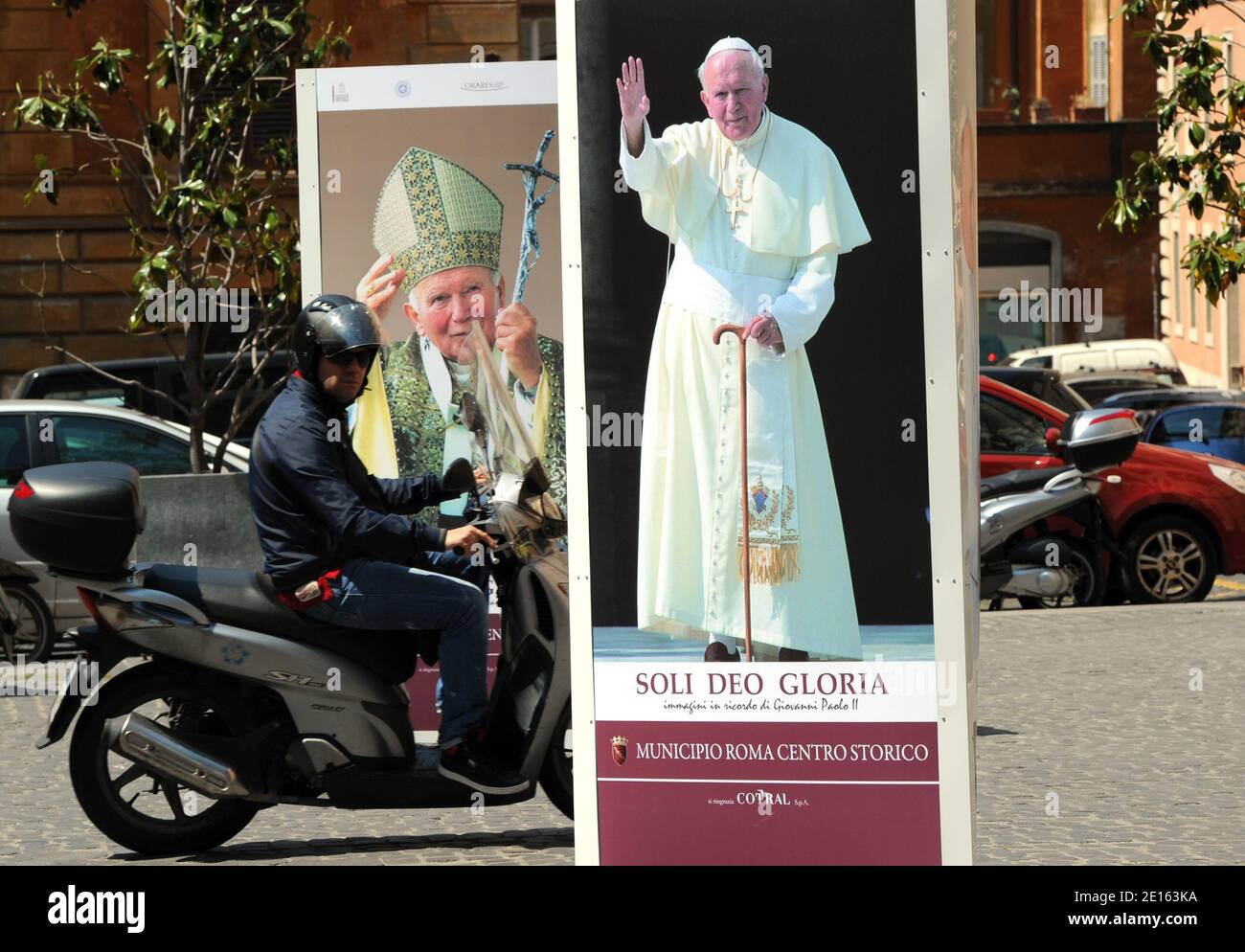People walk past placards showing pictures of late pope John Paul II ...