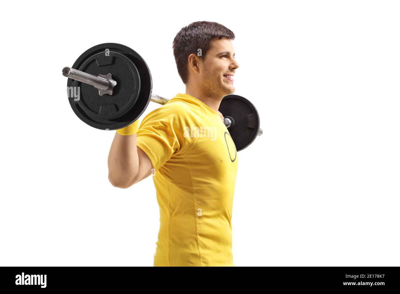 Smiling young man standing and lifting weights on shoulders isolated on ...