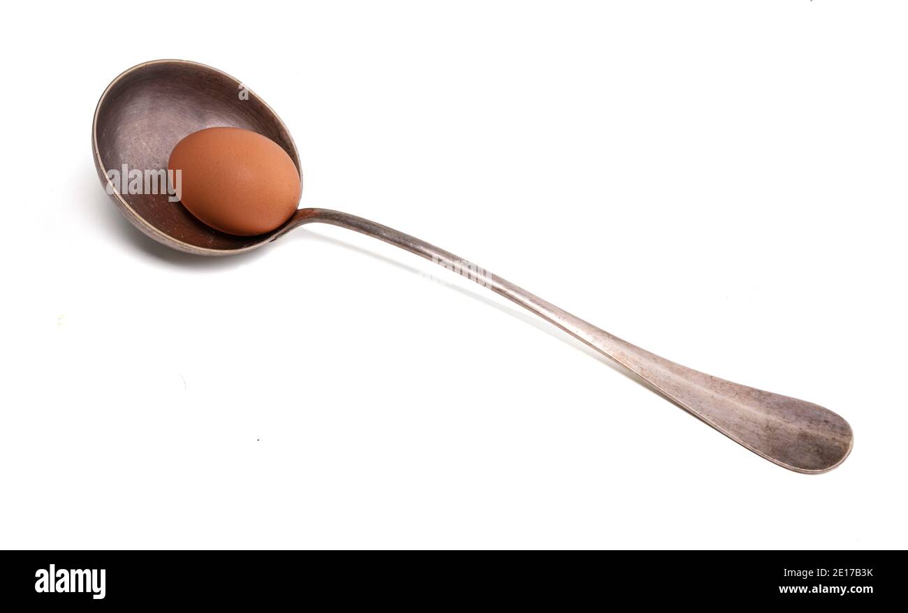 Silver ladle with an egg inside on a white background Stock Photo - Alamy