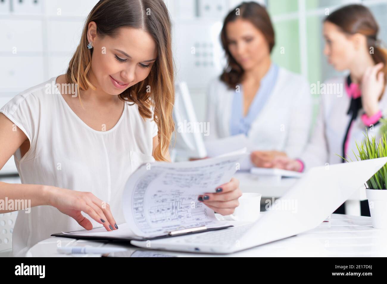 Young women sit at the table and work in a modern office Stock Photo ...