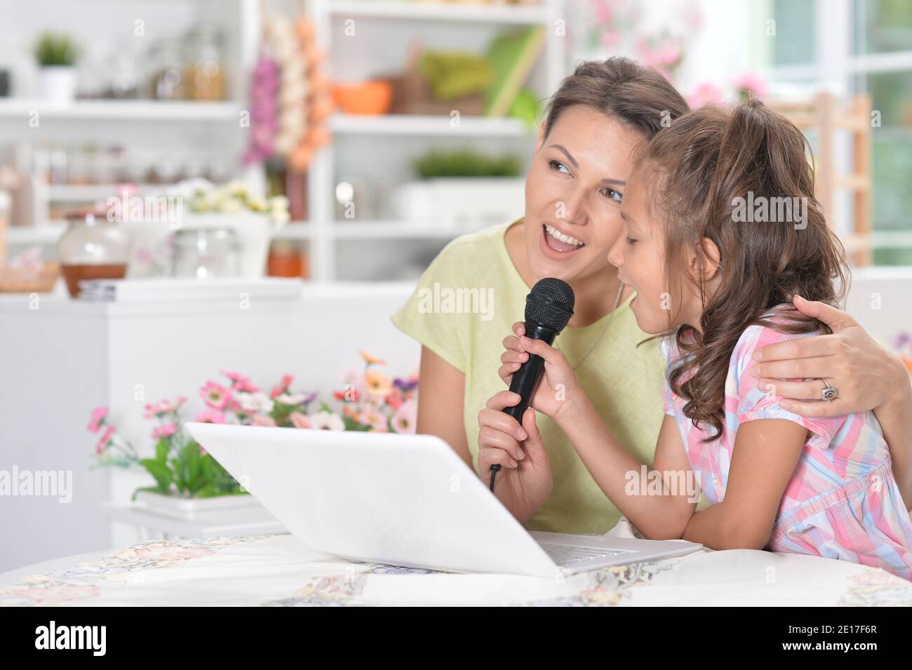 Mother and daughter singing karaoke with microphone together Stock ...