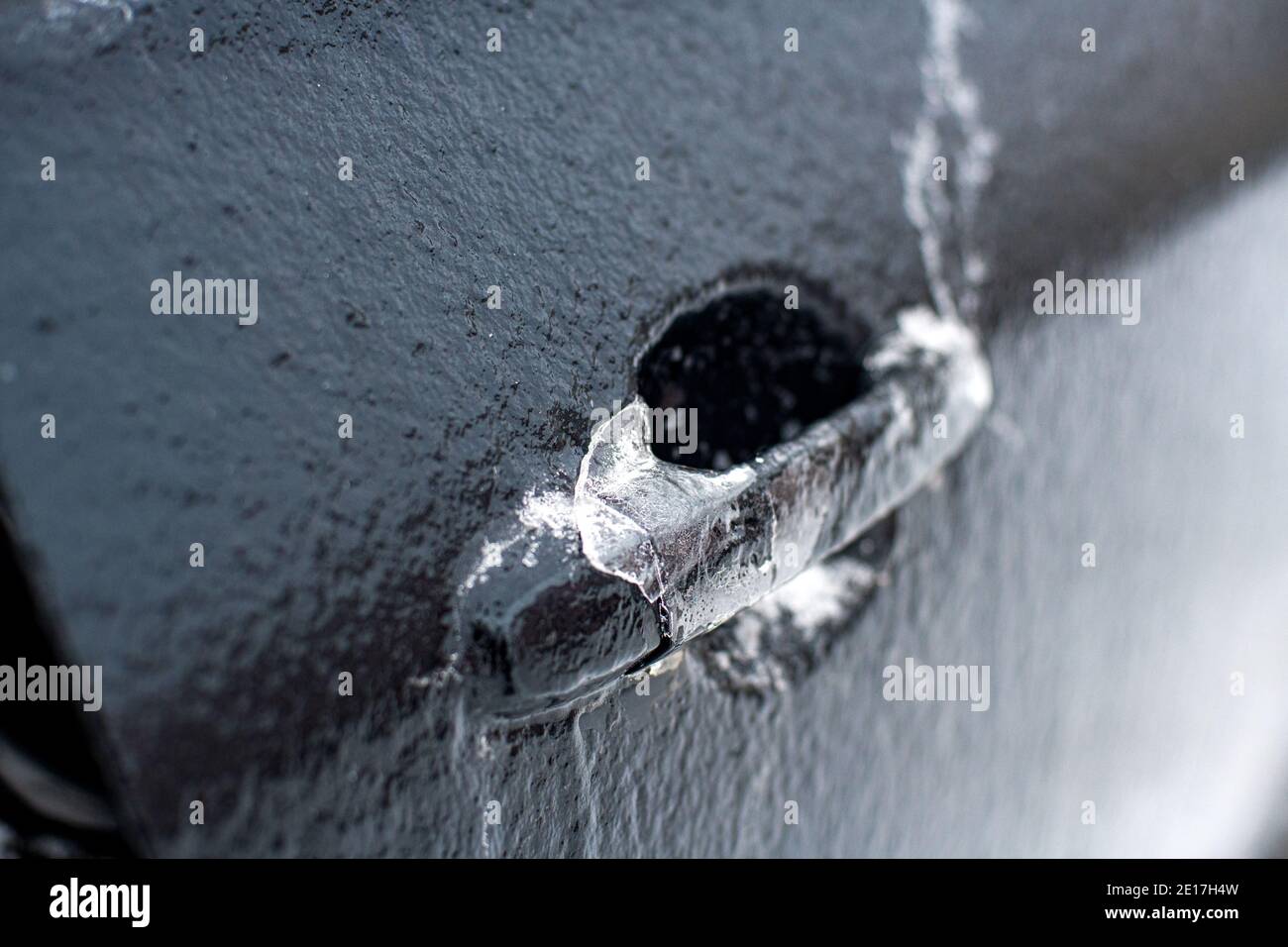 Car door opener handle with ice on top at shallow depth of field ...