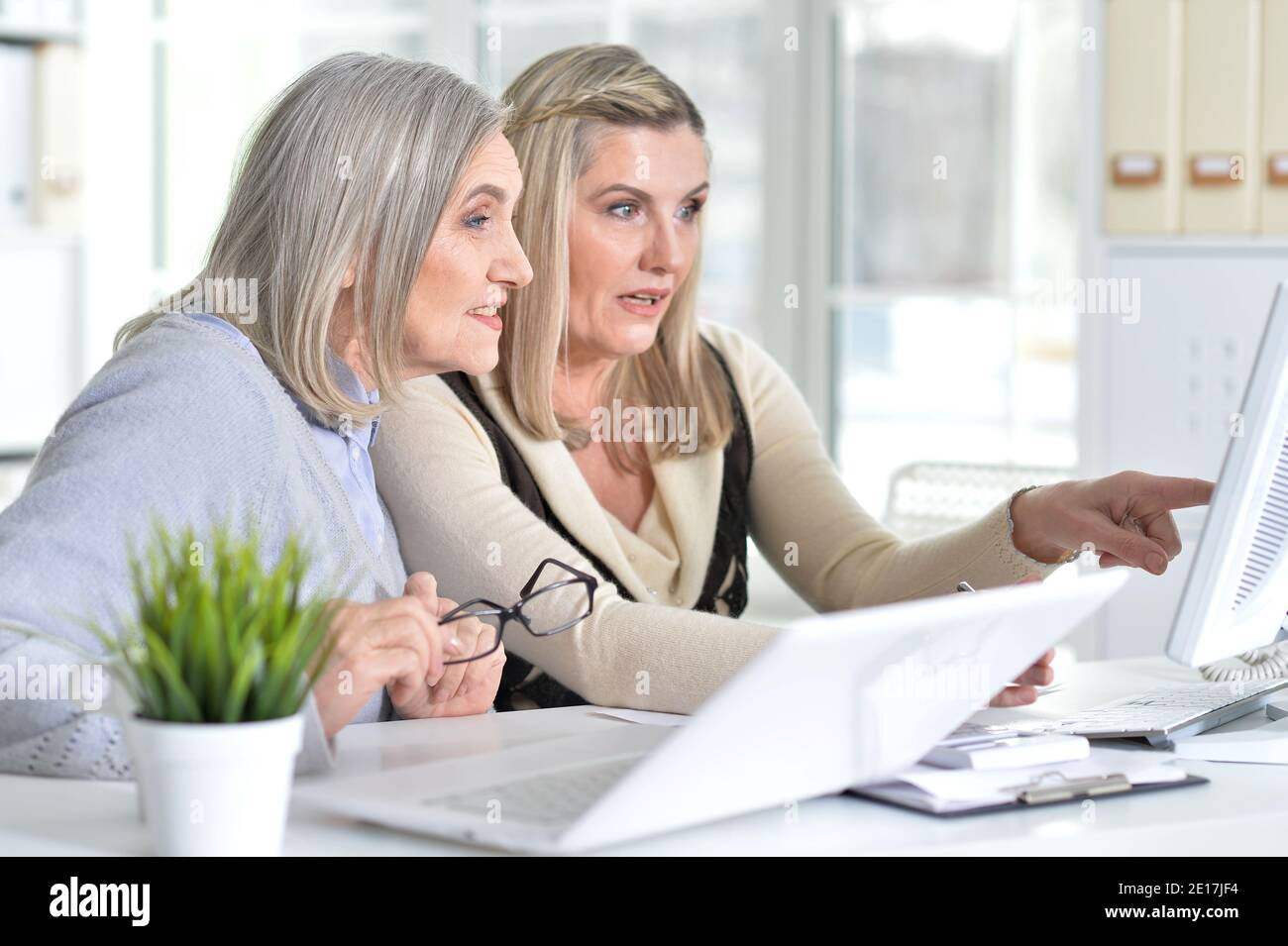 Portrait of two excited mature women working in office Stock Photo - Alamy