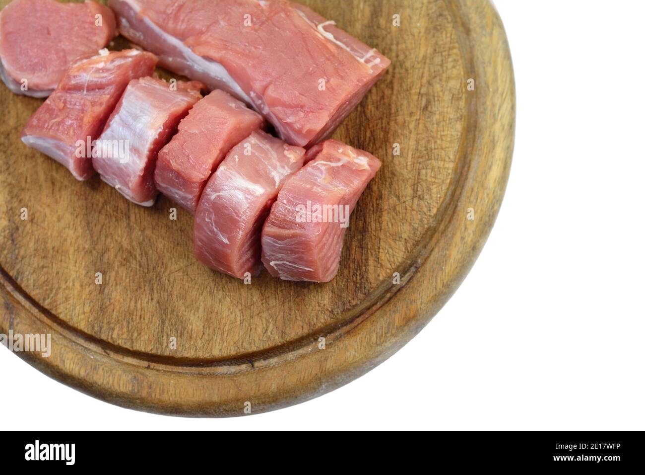 Fresh raw beef meat slices on a round wooden board isolated over white ...