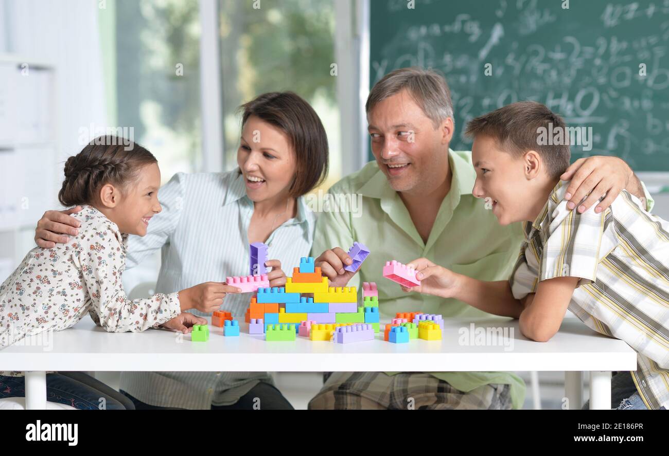 Parents and children playing with colorful plastic blocks at classroom ...