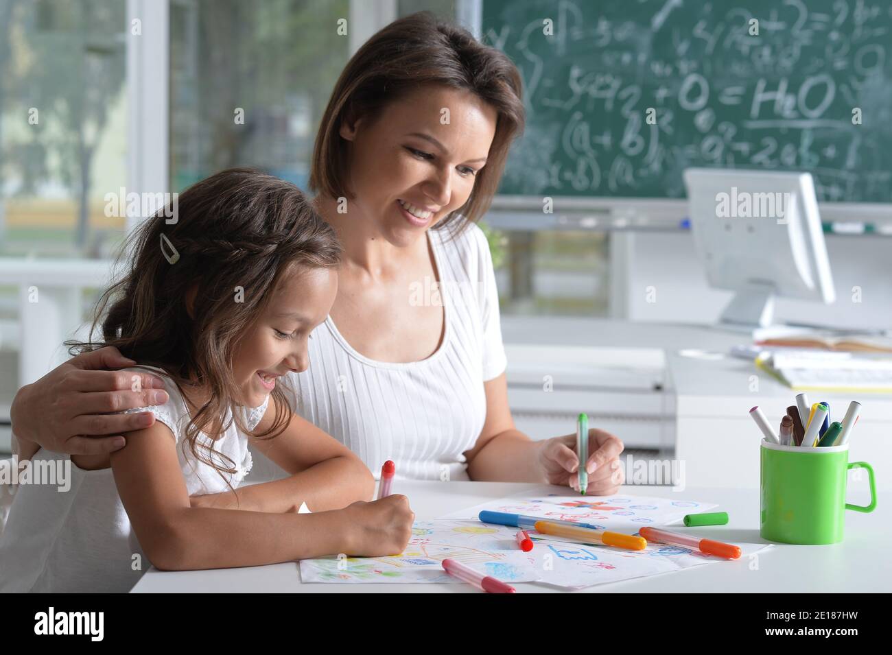 Portrait of cute girl with mother drawing Stock Photo - Alamy