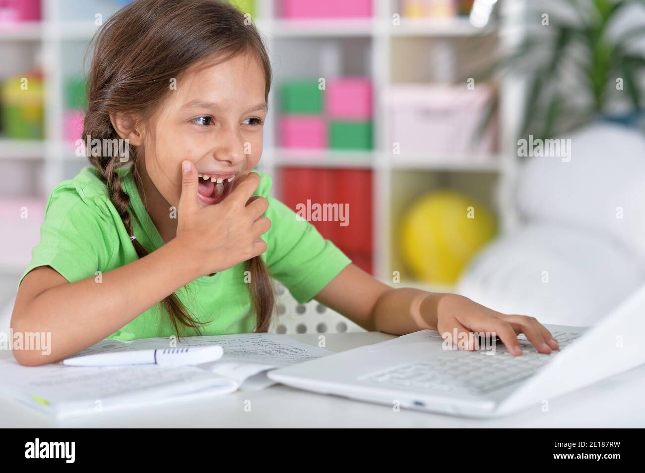 Portrait of concentrated little girl with laptop studying Stock Photo ...