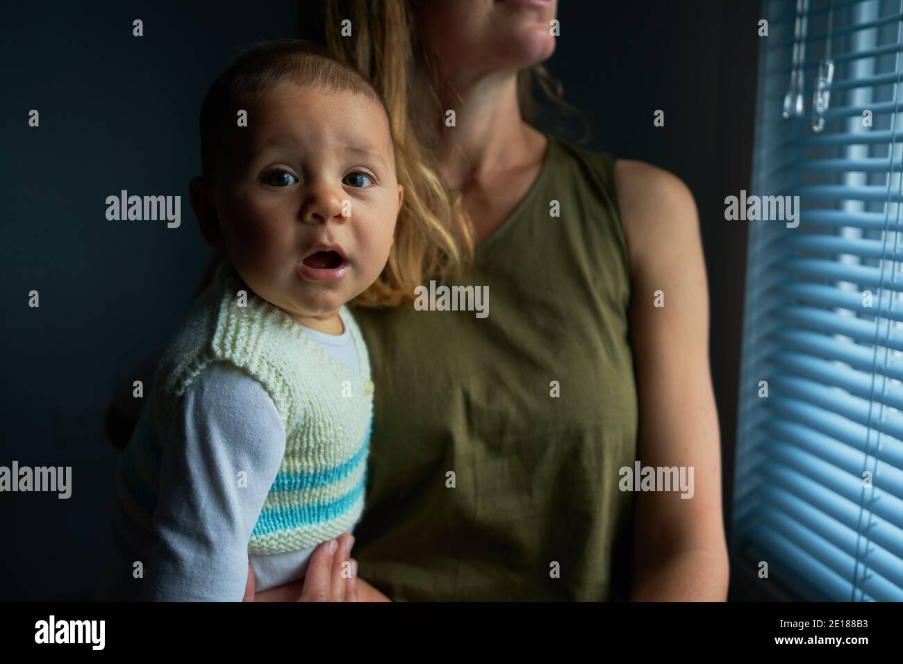 A young mother is sitting by the window with her baby Stock Photo - Alamy